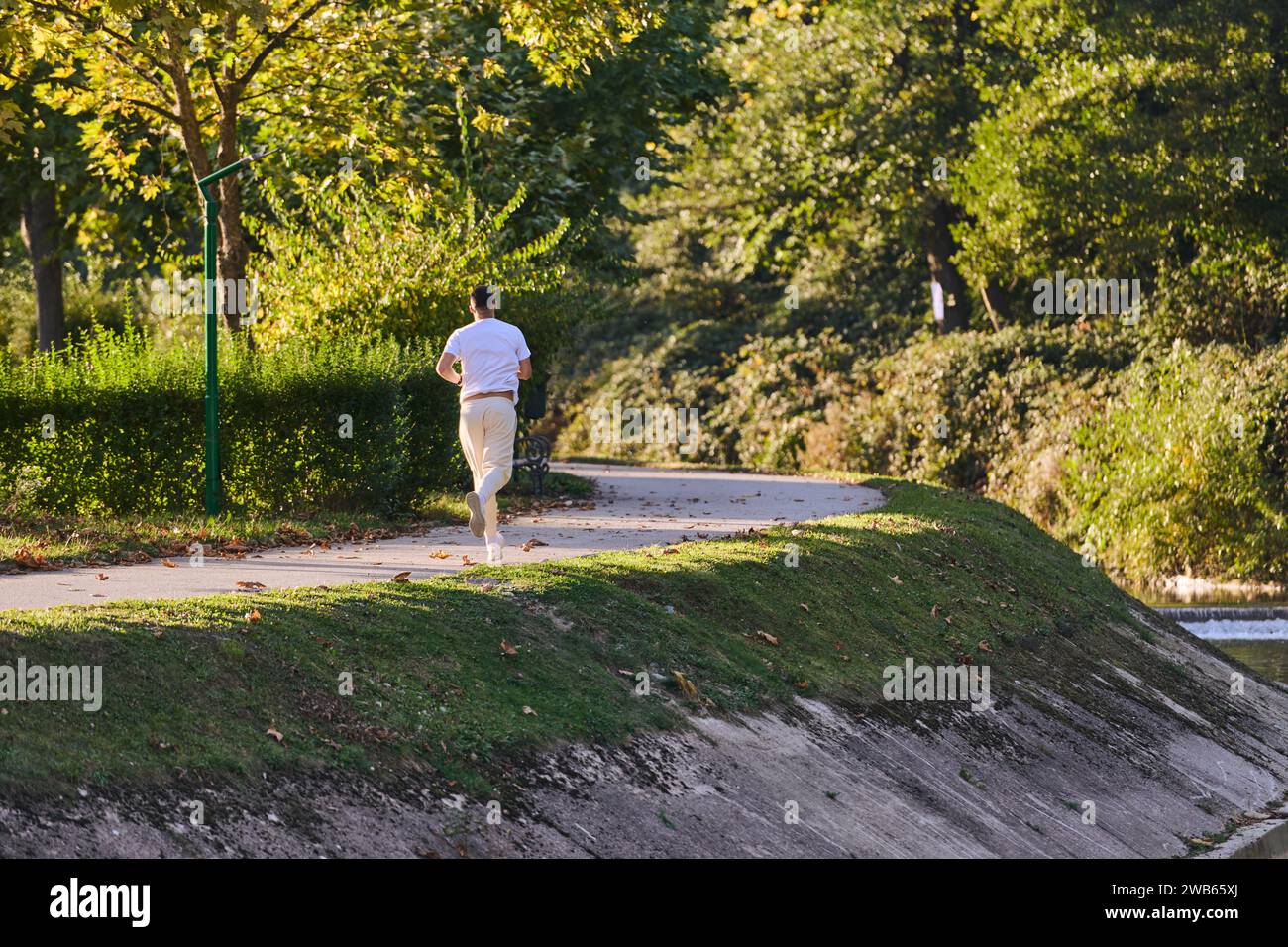A handsome man maintains his healthy lifestyle as he runs along ...