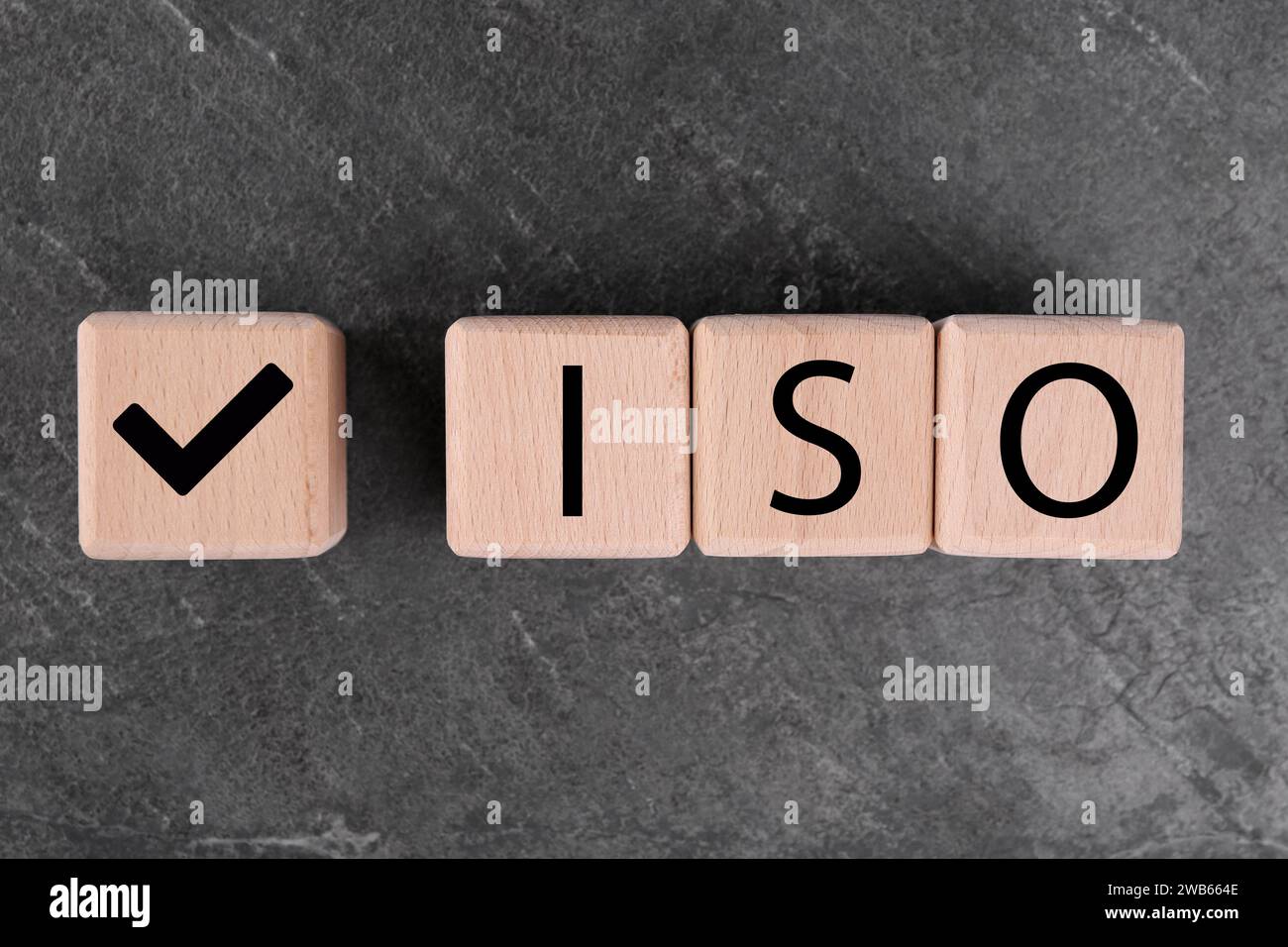 Cubes with check mark and abbreviation ISO on gray textured table, top ...