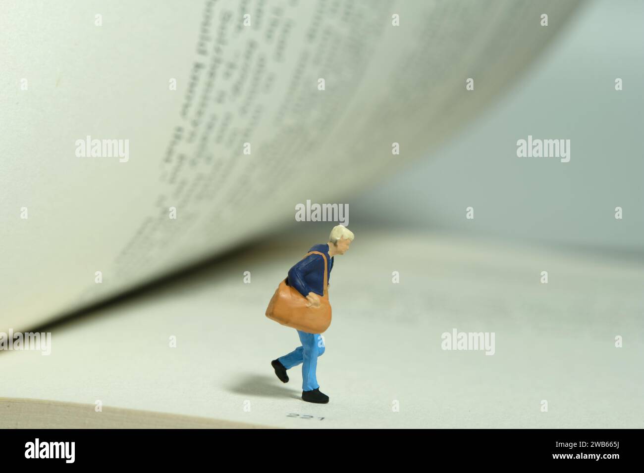 Miniature tiny people toy figure photography. A college student running ...