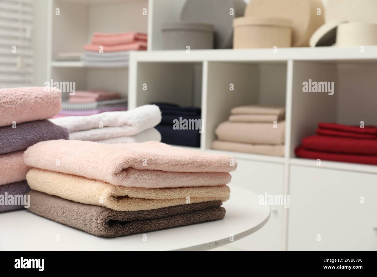 Stacked towels, decorative boxes and colorful bed linens in shop Stock ...