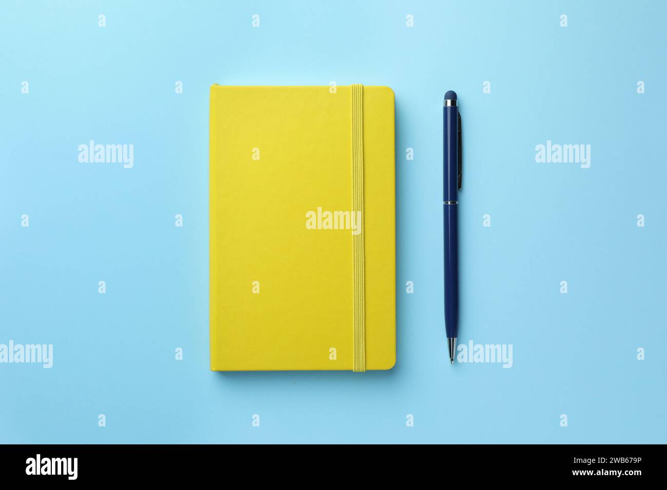 Closed yellow notebook and pen on light blue background, top view Stock ...