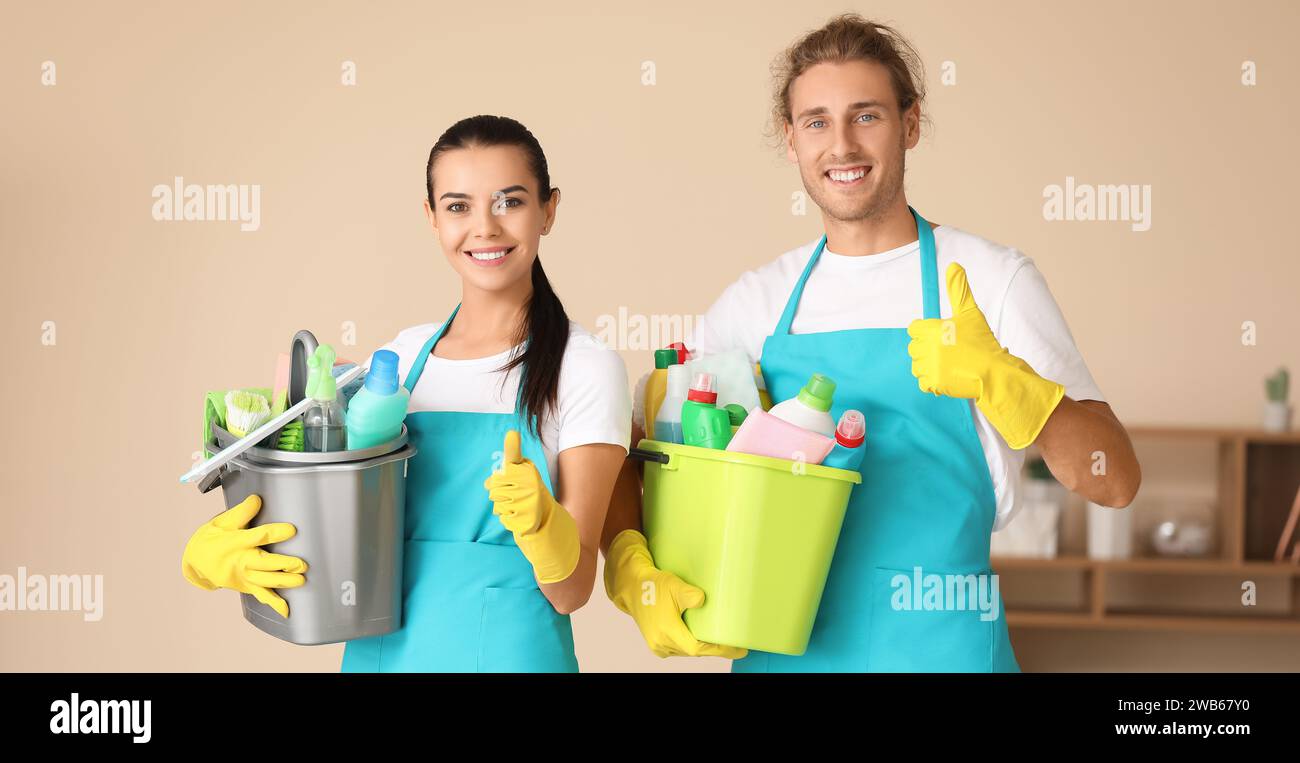 Team of janitors with cleaning supplies showing thumb-up in room Stock ...