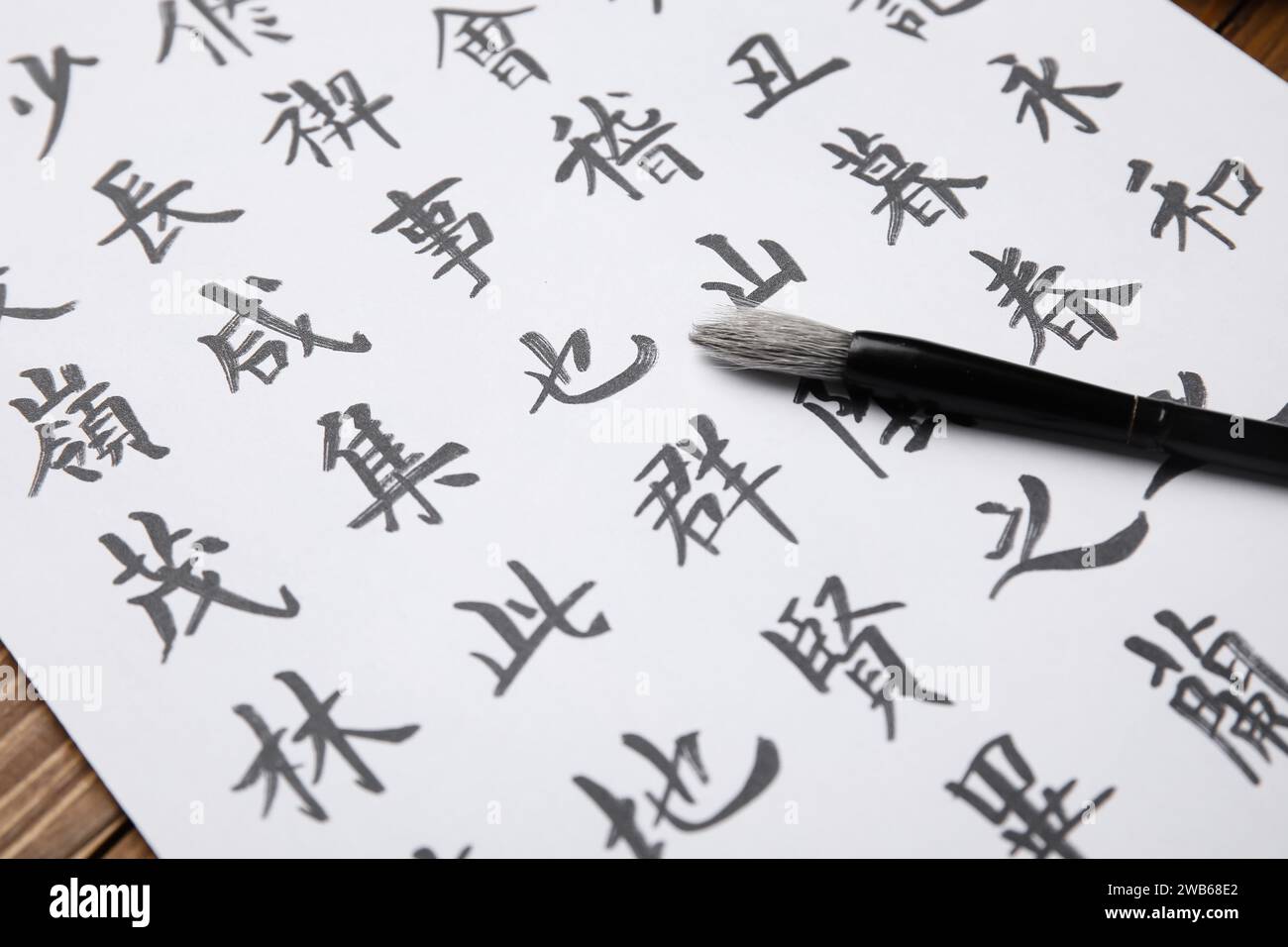 Paper sheet with Asian hieroglyphs and brush, closeup. International ...