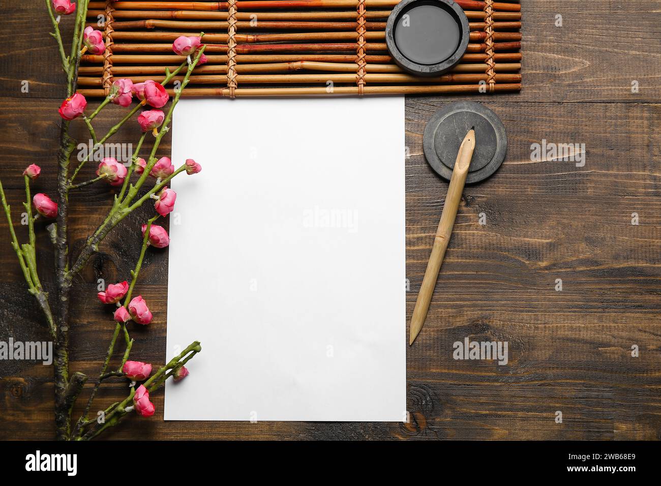 Composition with blank sheet of paper, ink, nib pen and blooming branch ...