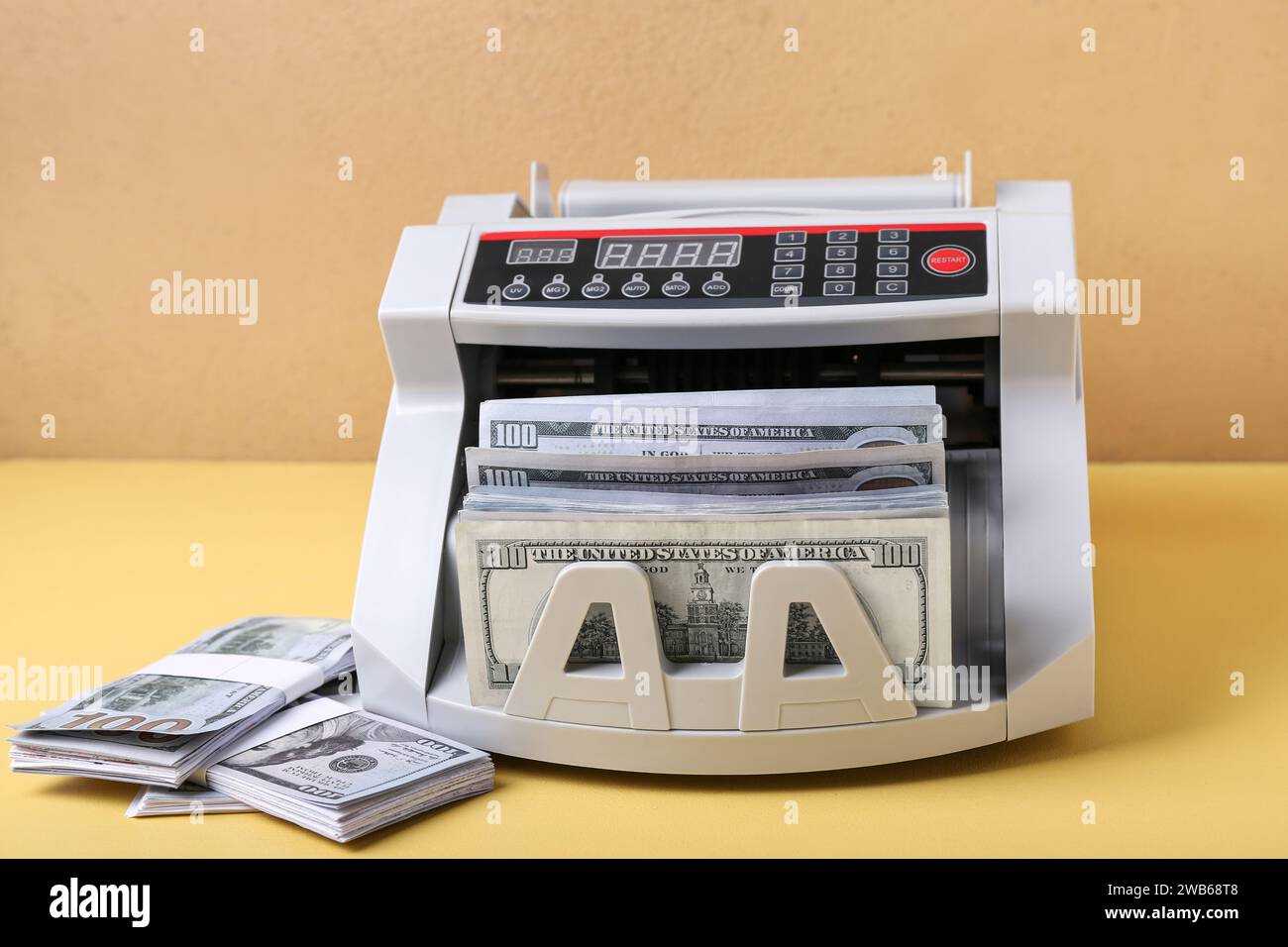 Modern cash counting machine with dollar banknotes on color background ...