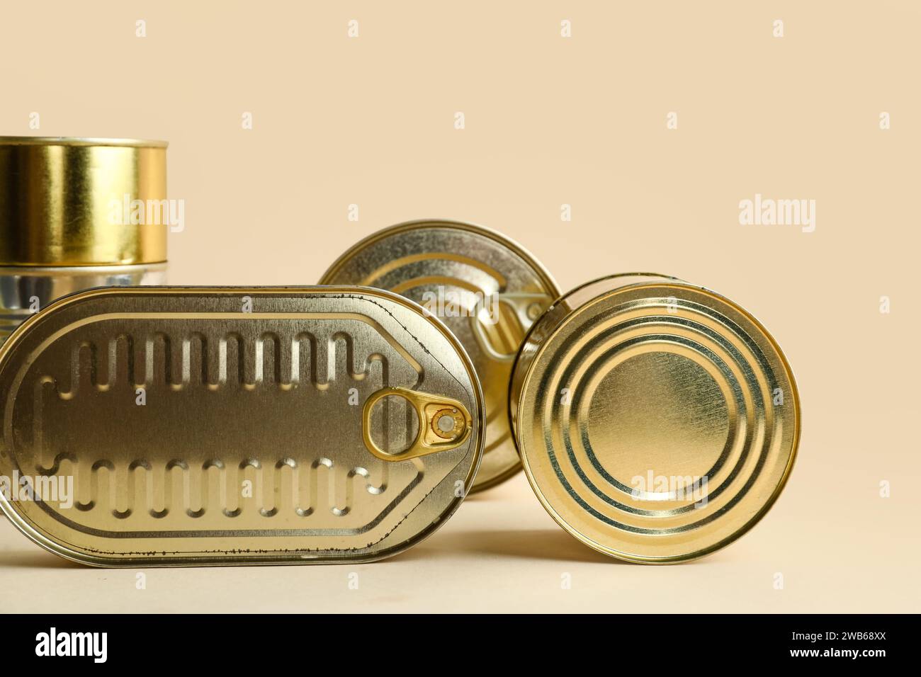 Tin cans with fish on beige background Stock Photo - Alamy