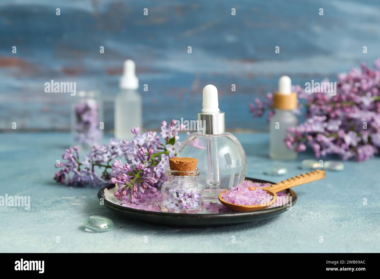 Bottles of cosmetic oil with beautiful lilac flowers and sea salt on ...