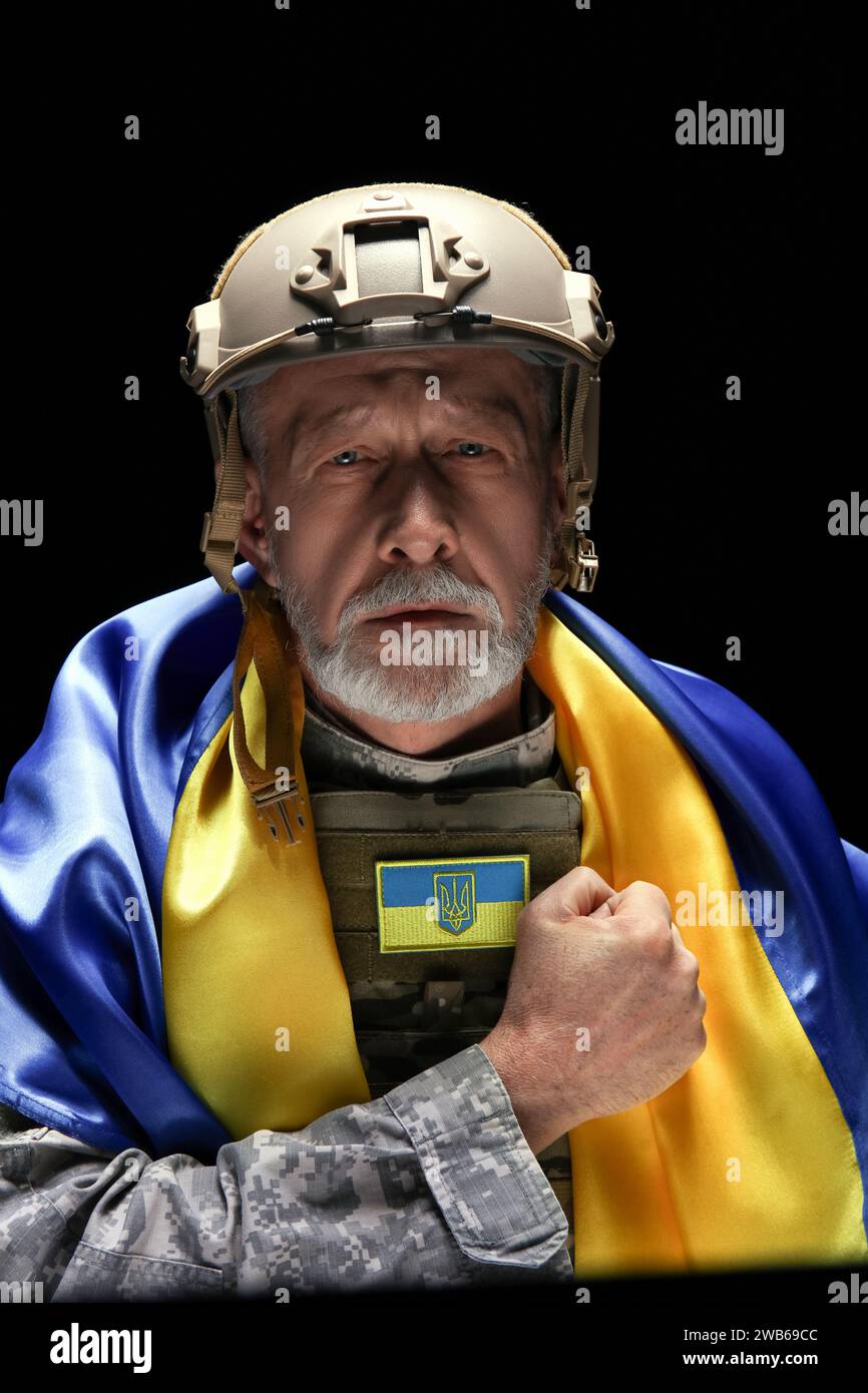Mature soldier with Ukrainian flag on dark background, closeup Stock ...