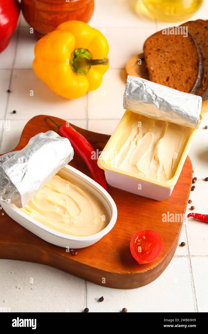 Wooden board with boxes of processed cheese, bread and vegetables on ...