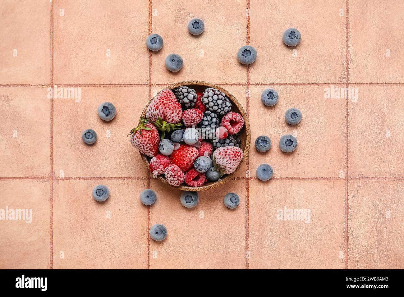 Bowl of different frozen berries on color tile background Stock Photo ...