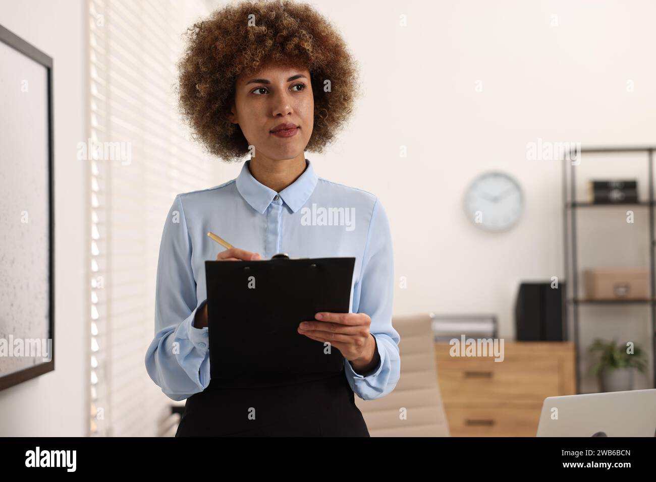 Notary with clipboard writing notes in office Stock Photo - Alamy