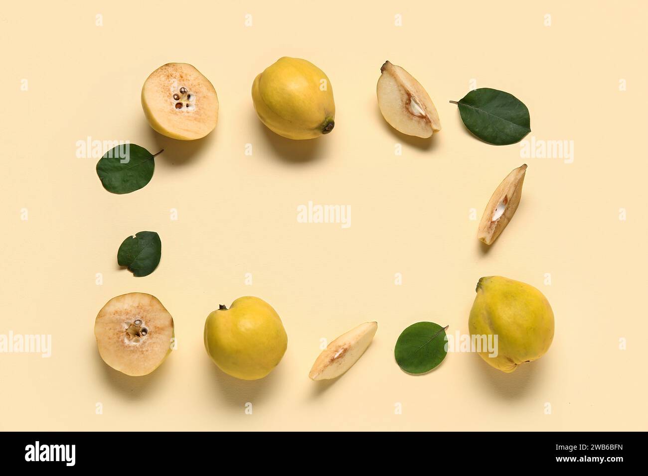Frame made of sweet ripe quinces and leaves on yellow background Stock ...