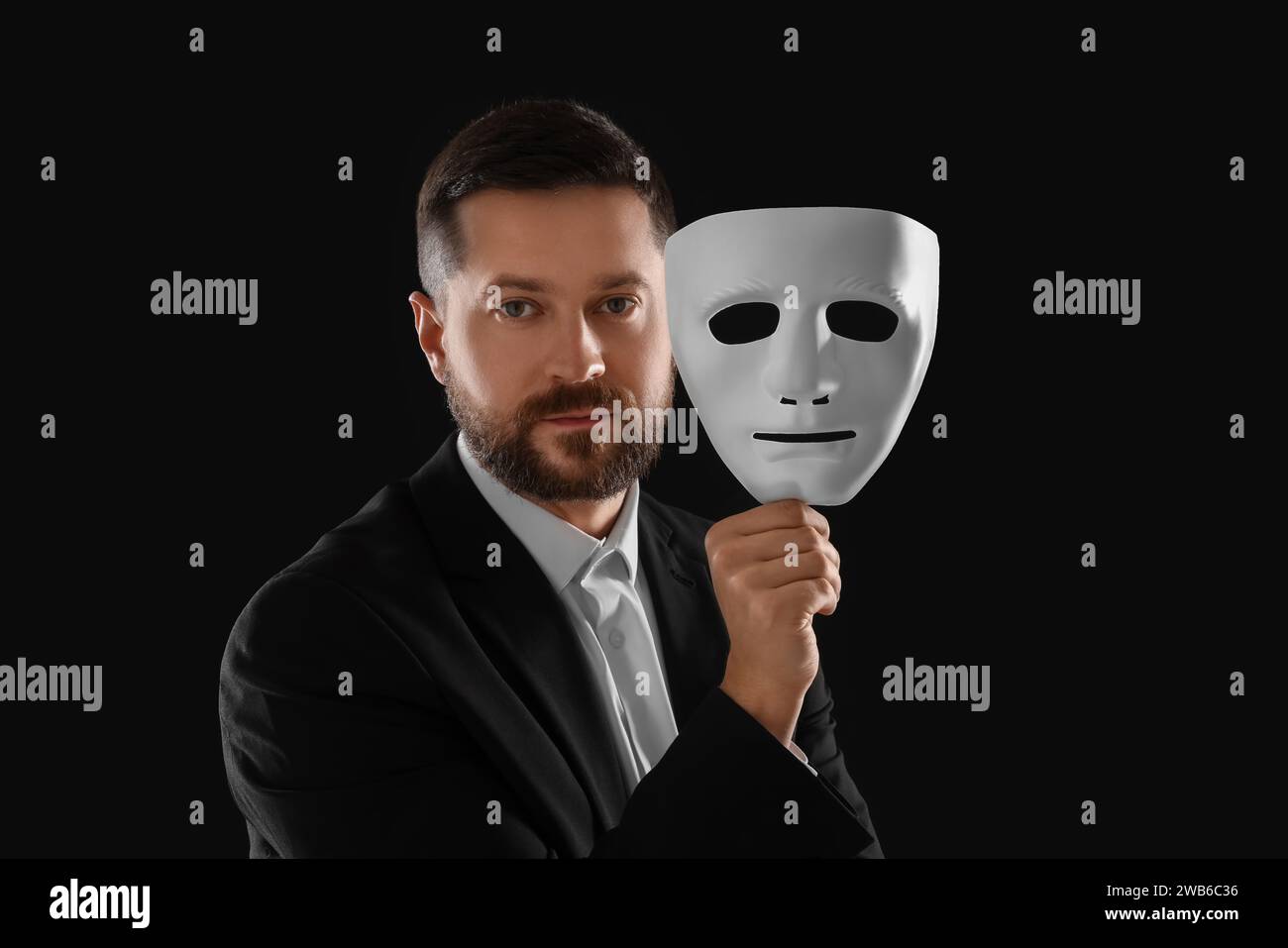 Multiple personality concept. Man with mask on black background Stock ...