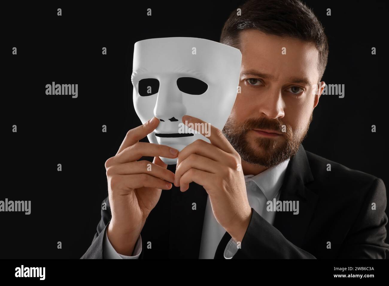 Multiple personality concept. Man with mask on black background Stock ...