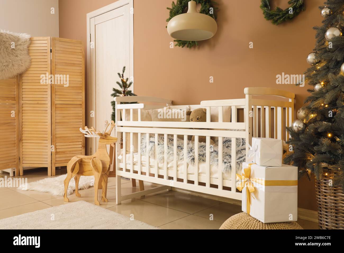 Interior of bedroom with baby crib and Christmas trees Stock Photo - Alamy