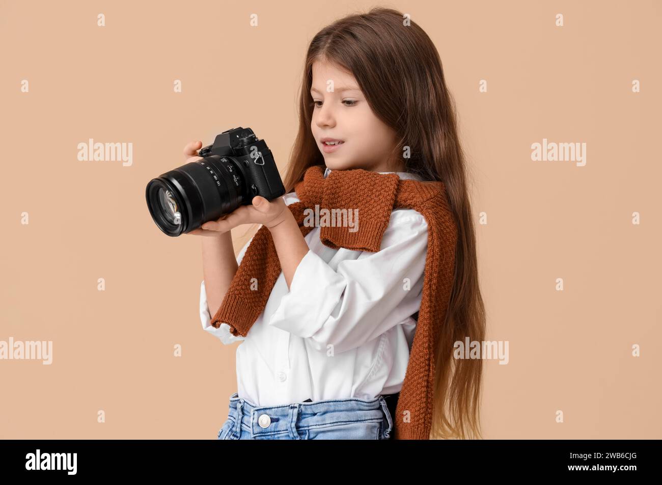 Cute little photographer with camera on beige background. Opposite Day ...