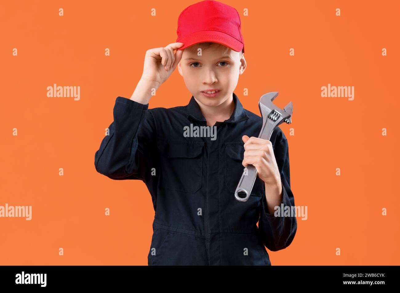 Cute little mechanic with wrench on orange background. Opposite Day ...