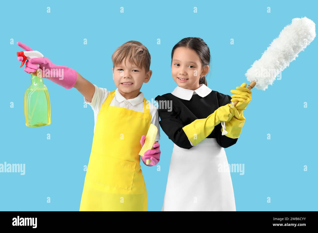 Cute little janitors with cleaning supplies on blue background ...