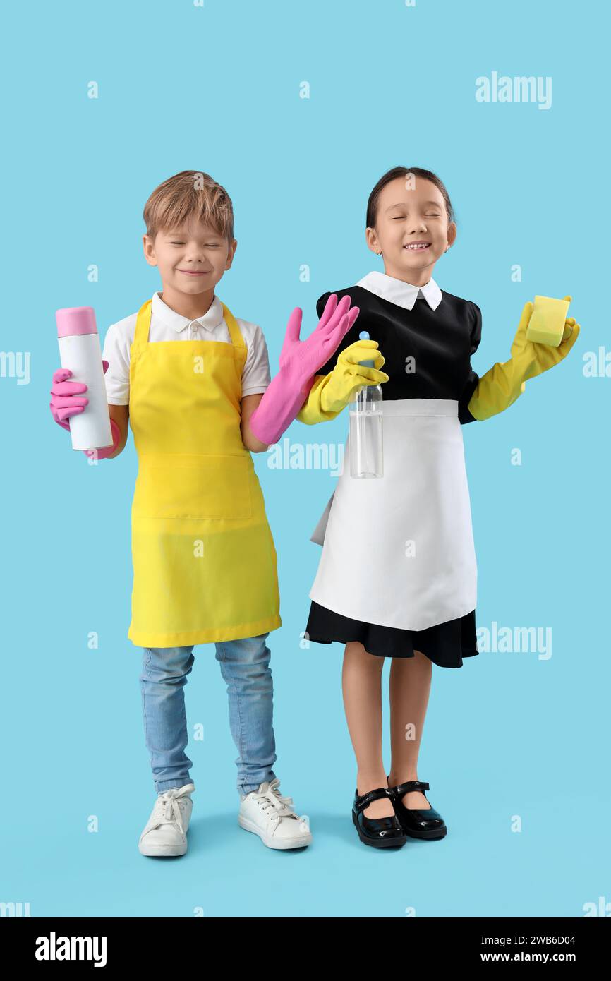 Cute little janitors with cleaning supplies on blue background ...