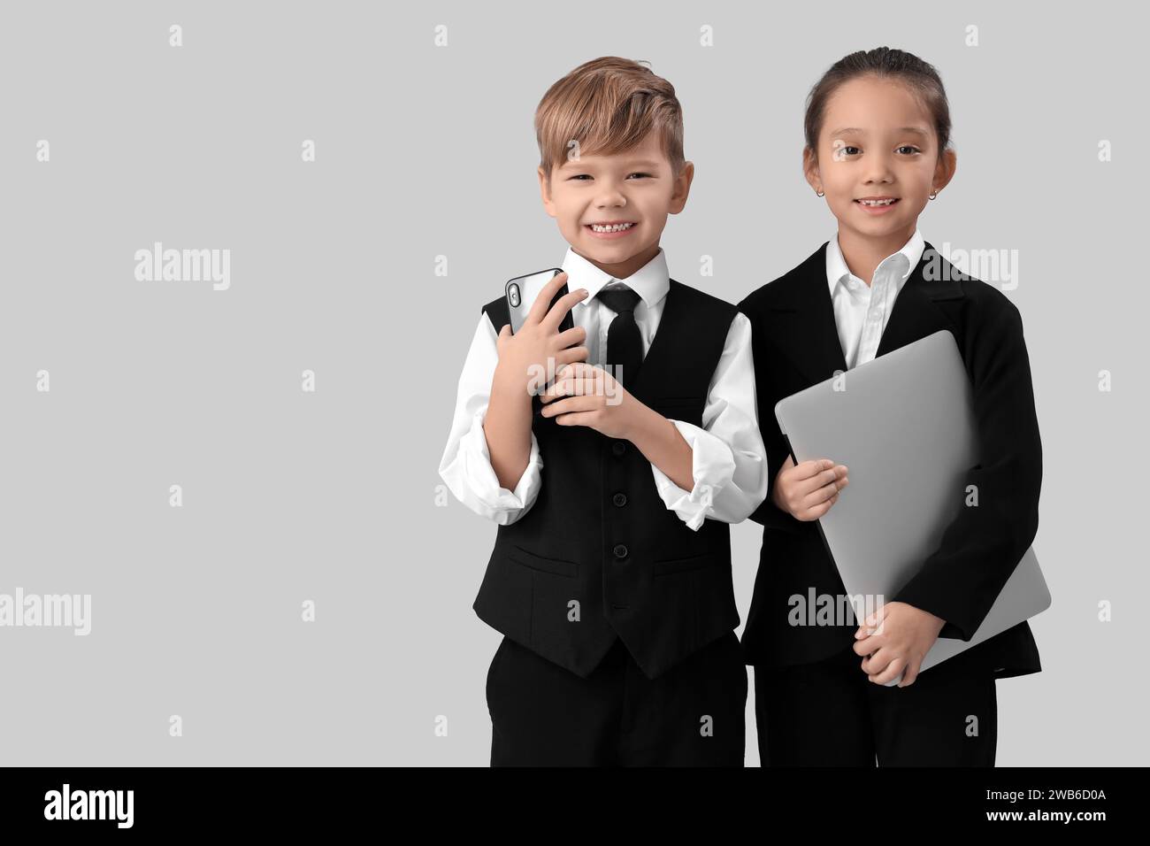 Cute little business colleagues with devices on light background ...