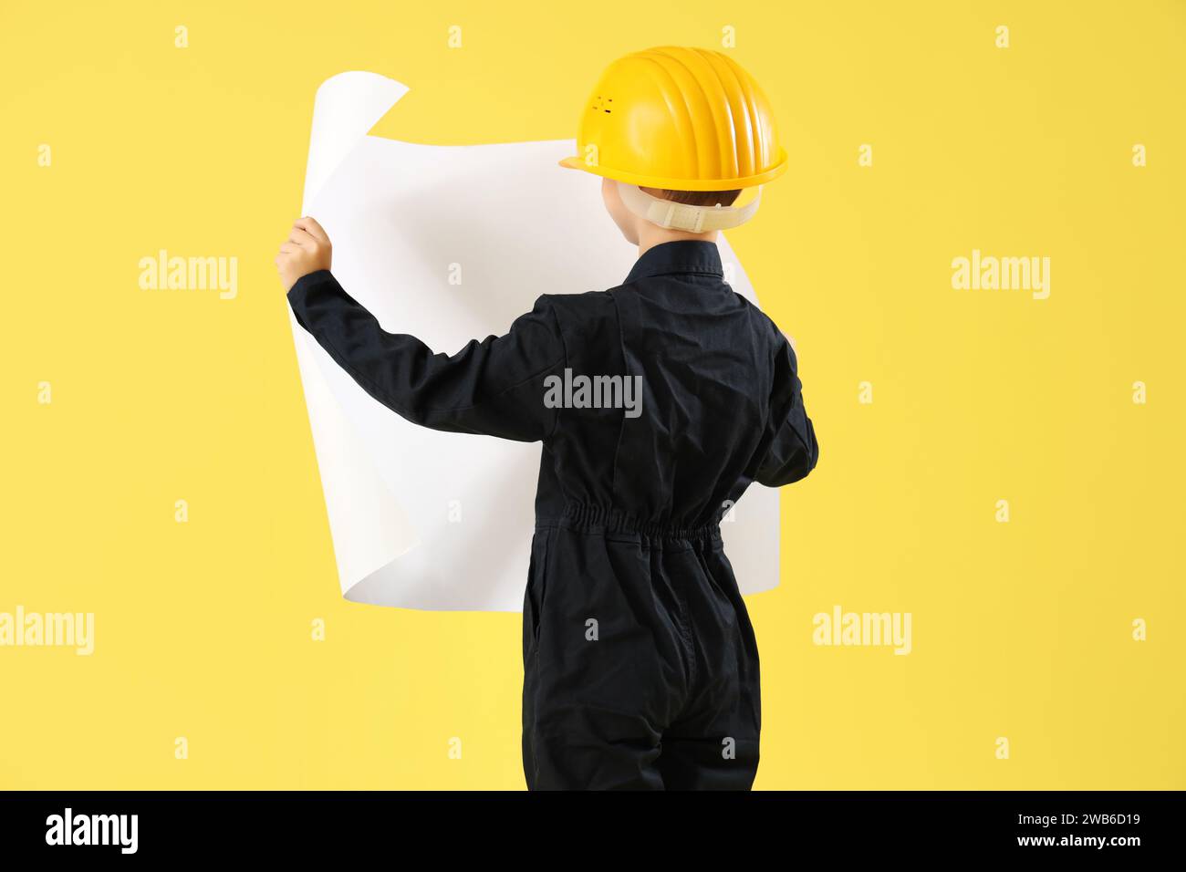 Cute little engineer with house plan on yellow background, back view ...