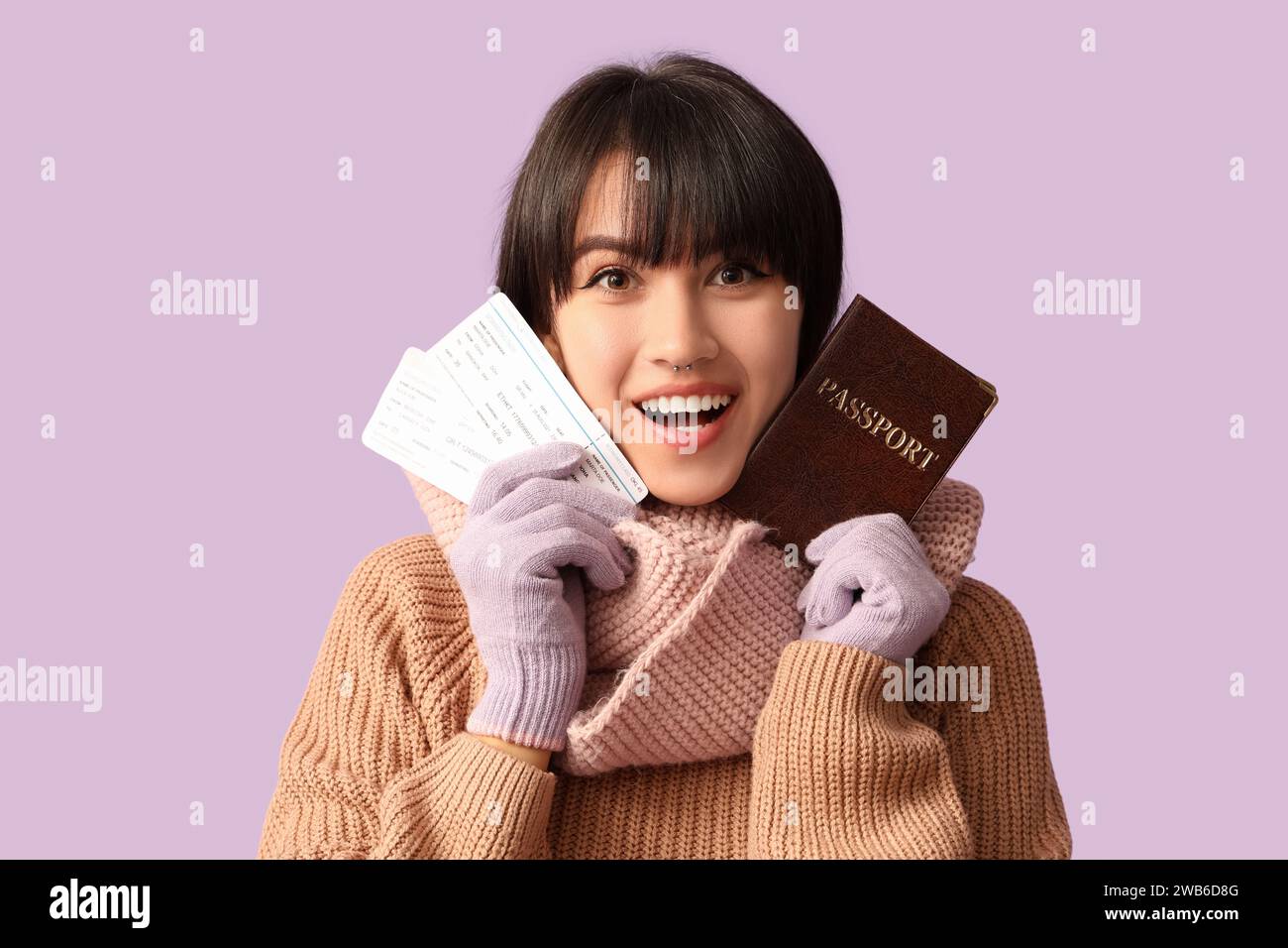 Beautiful young happy woman with passport and tickets on purple ...