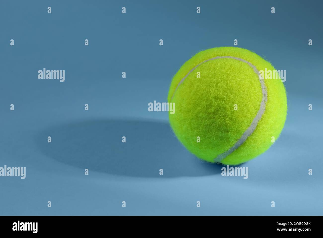 One tennis ball on light blue background, space for text Stock Photo ...