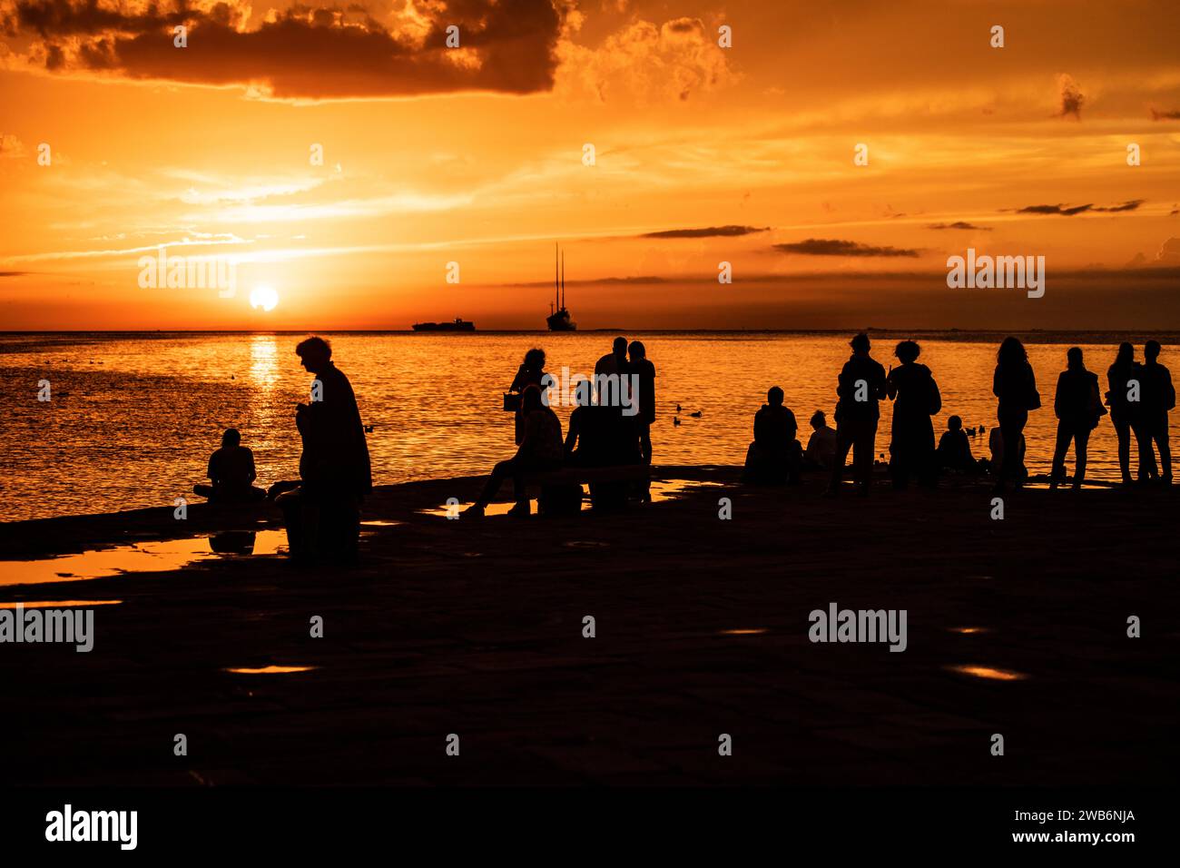 Trieste: people watching the sunset in Molo Audace (dock). Italy Stock ...