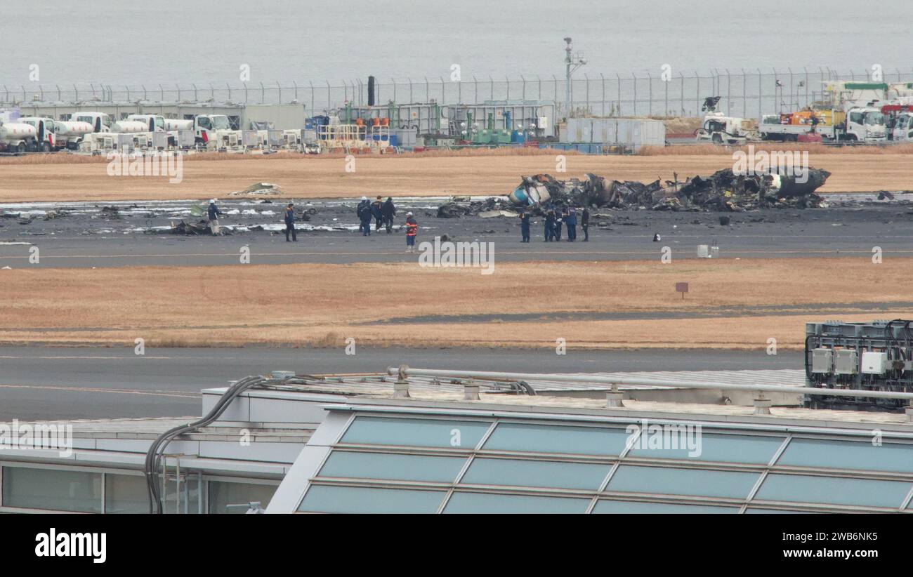 Officials investigate a burnt Japan Coast Guard aircraft MA722 Mizunagi ...