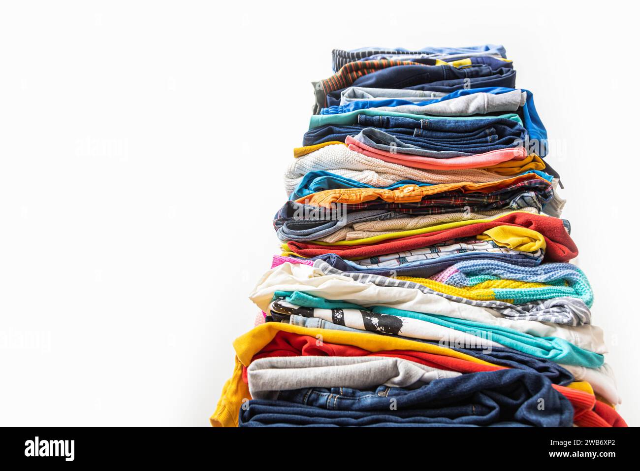 A very tall stack of folded colored clothes for charity, washing, ironing and sorting Stock ...