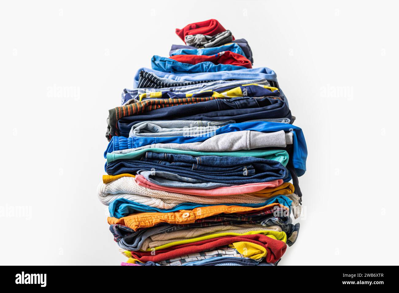 A very tall stack of folded colored clothes for charity, washing ...