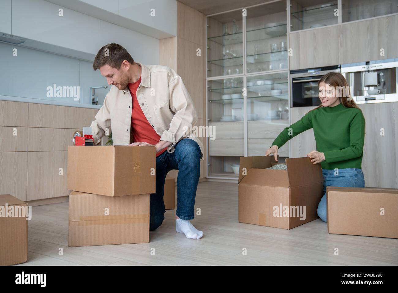 Happy family couple man woman packing boxes on kitchen moving to new ...