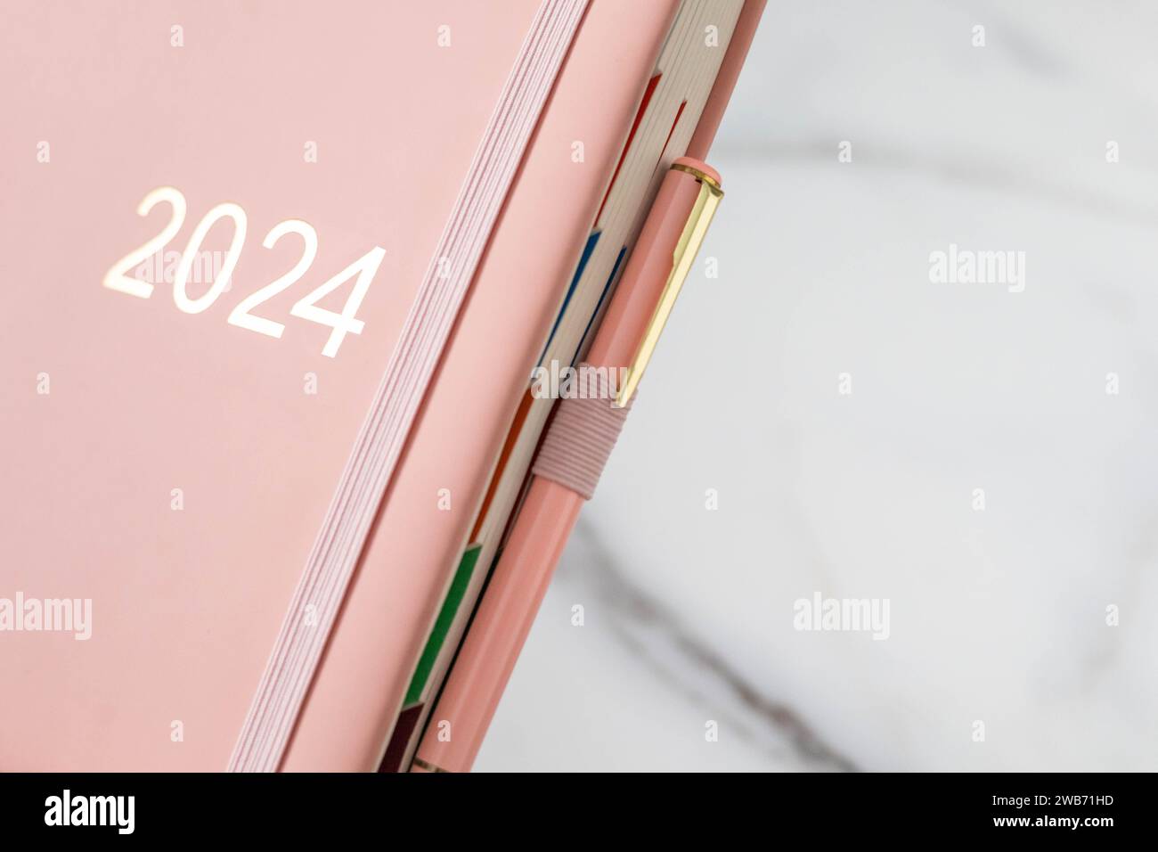 Pink coral colored diary for the year 2024, pen, marble background ...