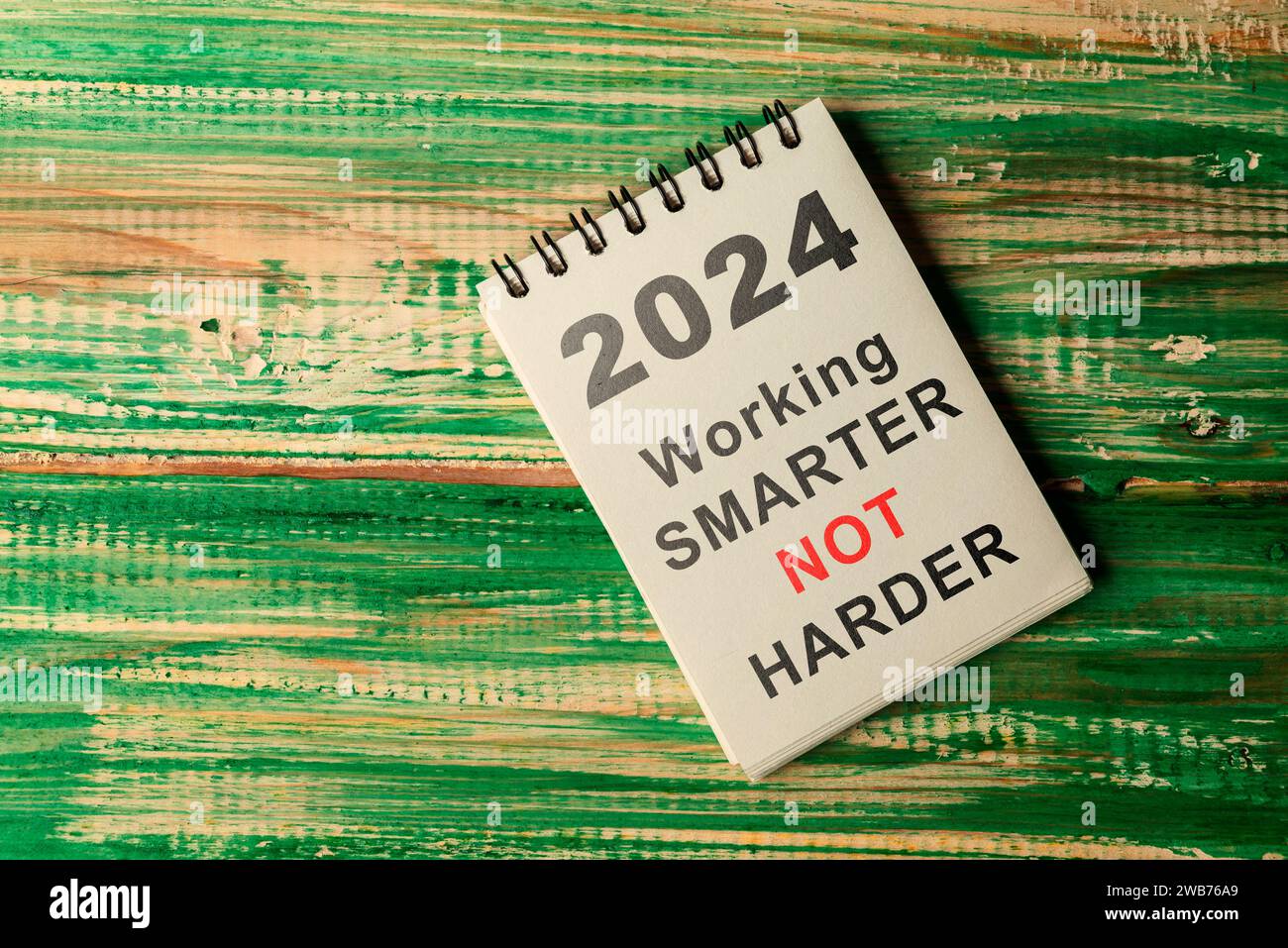 Notebook with 2024 Working Smarter Not Harder text on wooden table ...
