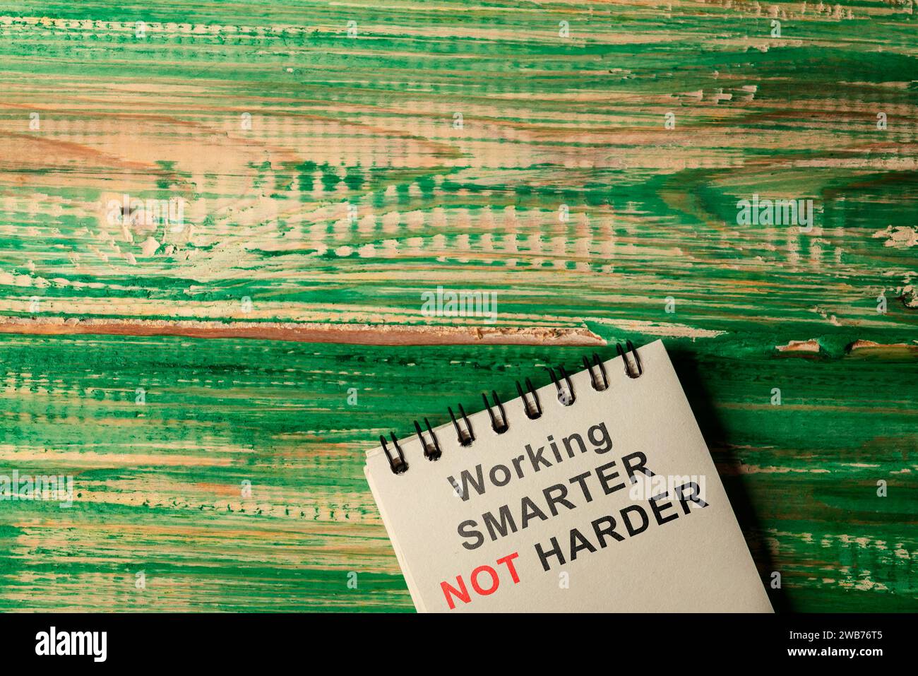 Notebook with Working Smarter Not Harder text on wooden table. Human ...