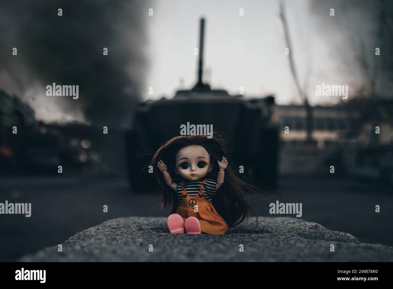 A frightened doll sits on the ground surrounded by fire and smoke. A ...