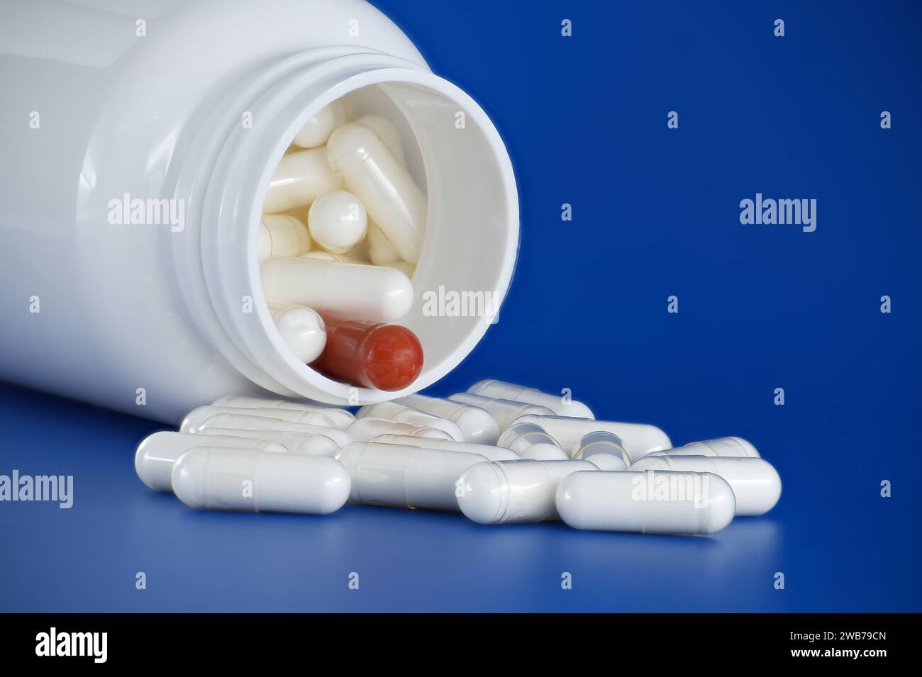 Health-related scene involving a white bottle filled with capsules that ...