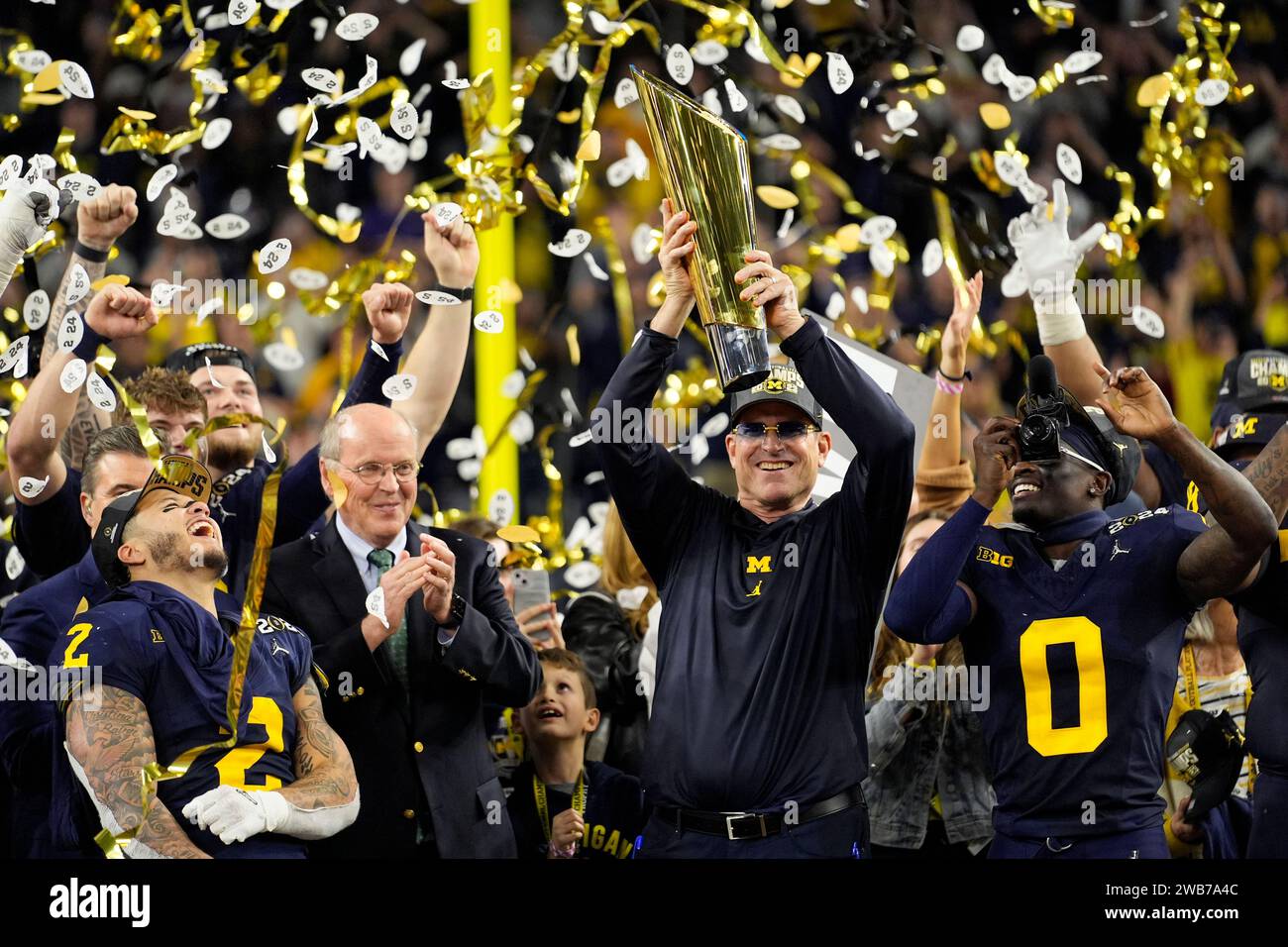 Michigan head coach Jim Harbaugh celebrates with the trophy after their ...