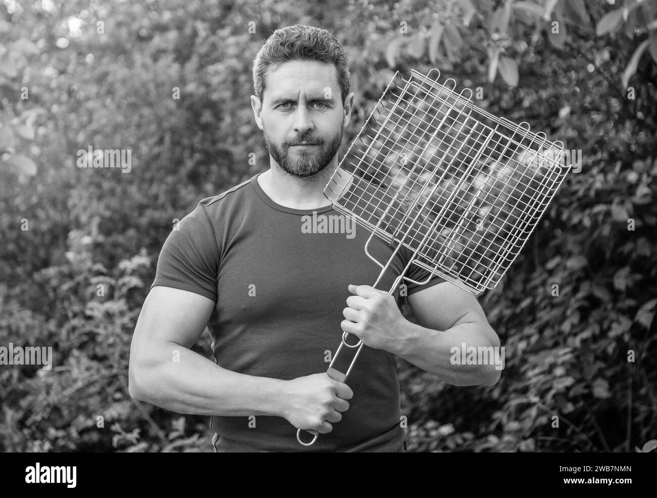 photo of man with barbecue grill utensil outdoor Stock Photo - Alamy
