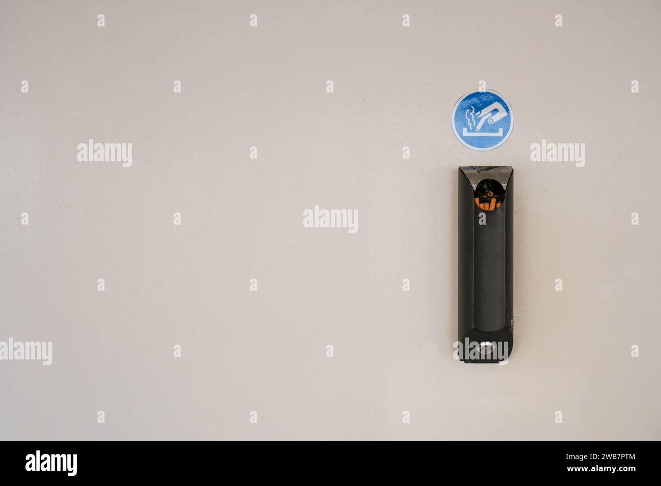 close-up, horizontal view of a black ashtray affixed to a light-colored ...