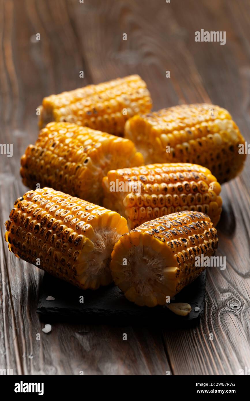 Slate tray with Pieces of Grilled corn on the cob on kitchen table ...