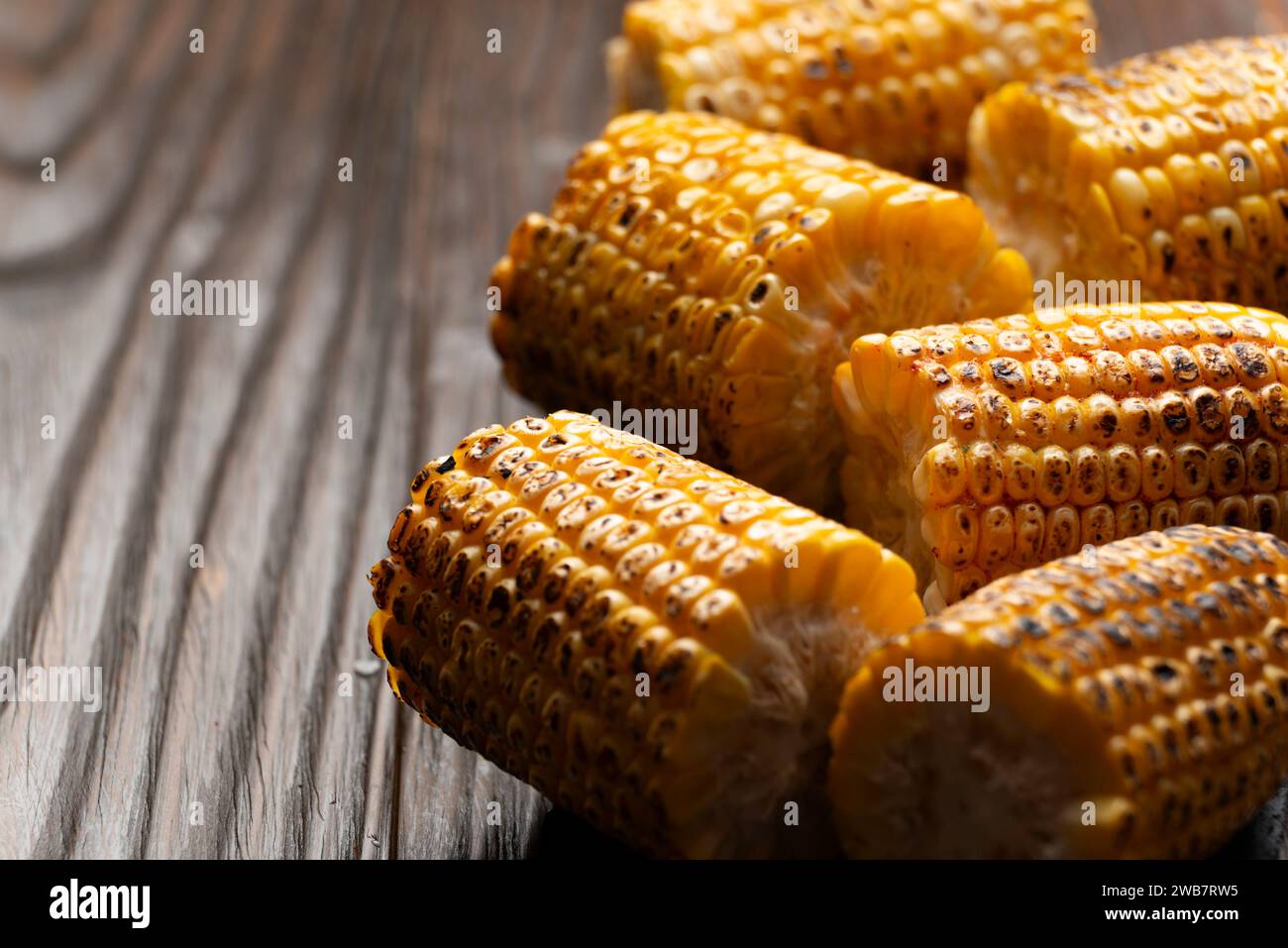 Slate tray with Pieces of Grilled corn on the cob on kitchen table ...