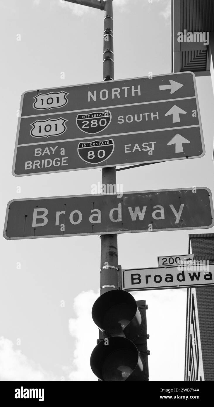 Traffic light and Broadway Bay bridge road signs with direction ...