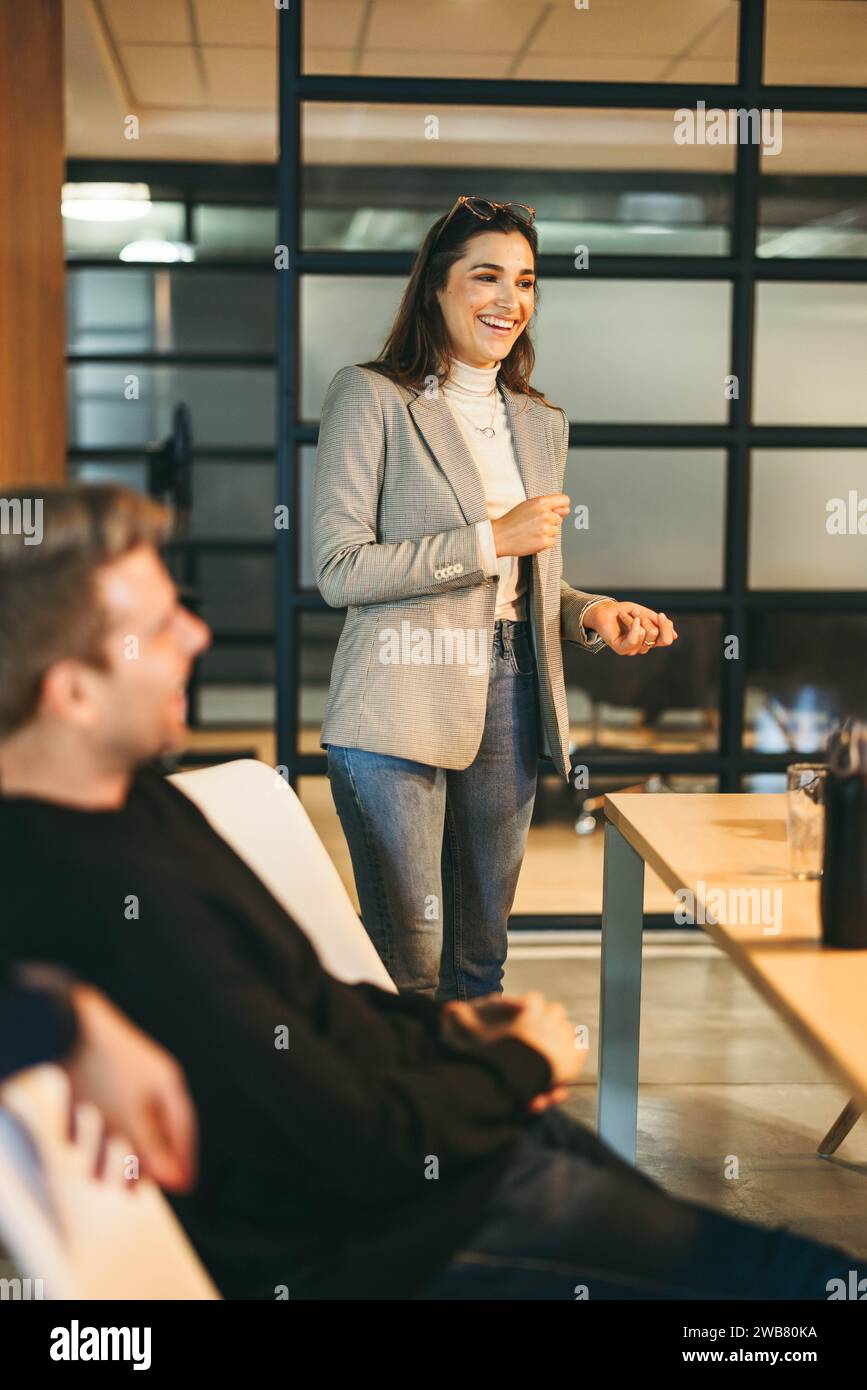 Happy group of professionals in a vibrant office engage in creative brainstorming, discussing ...