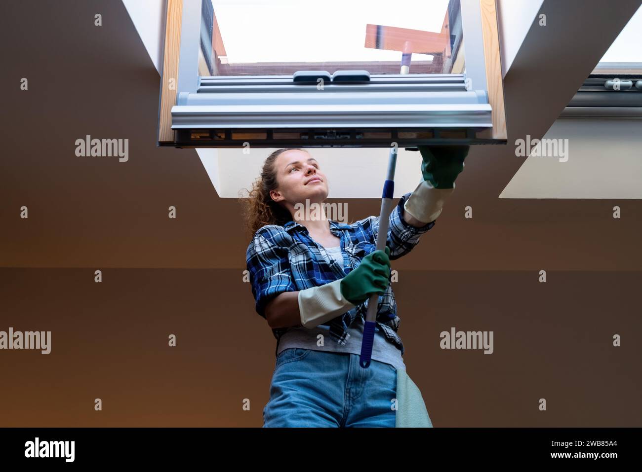 Cleaning service worker woman cleans skylight window Stock Photo - Alamy