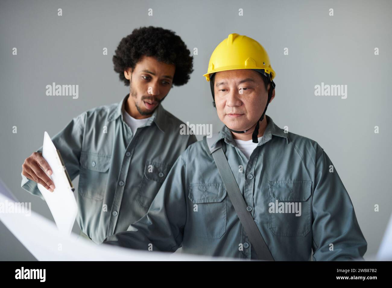 Diverse team of construction workers discussing details of building ...