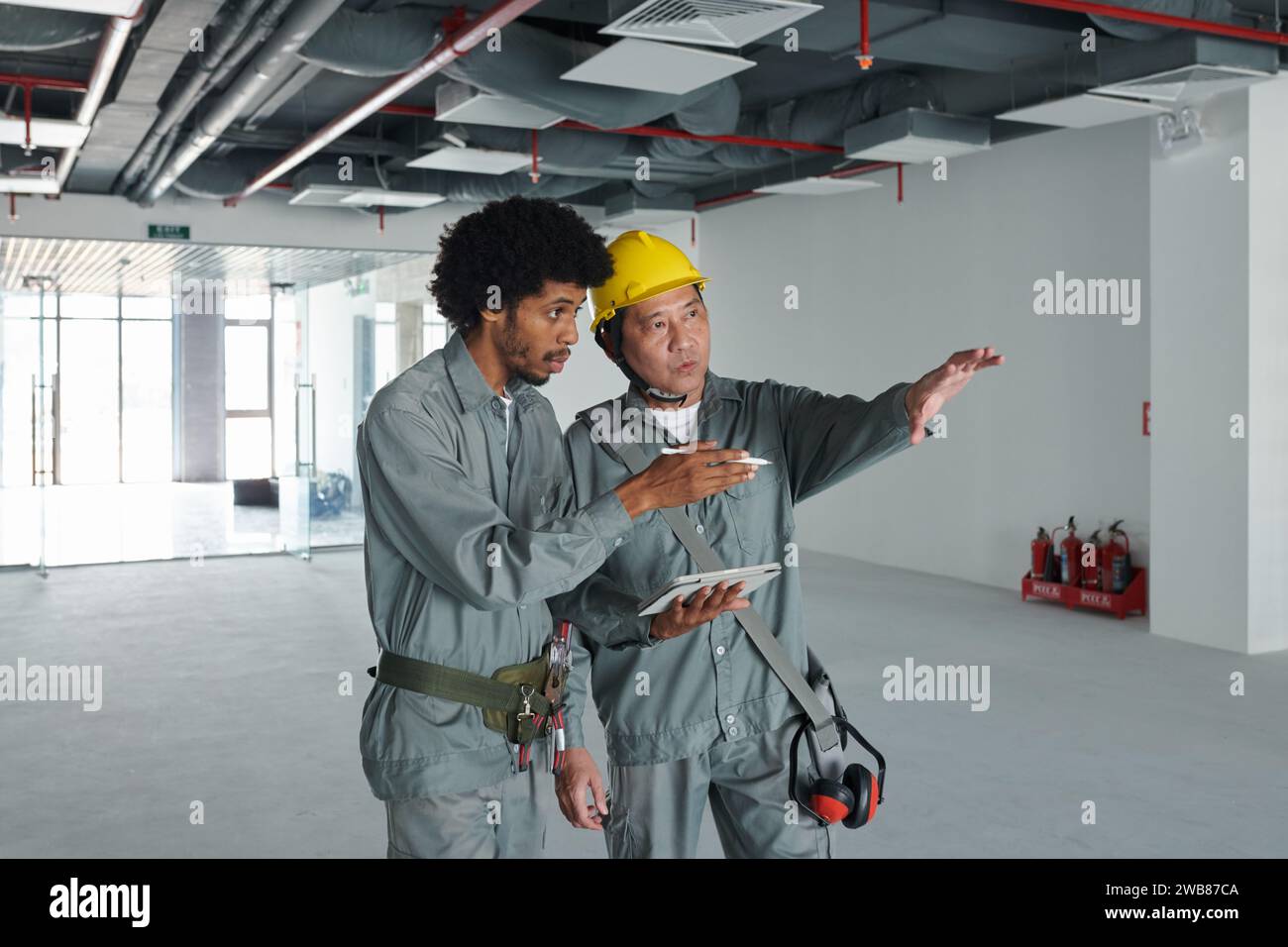 Construction workers discussing building renovation process Stock Photo ...