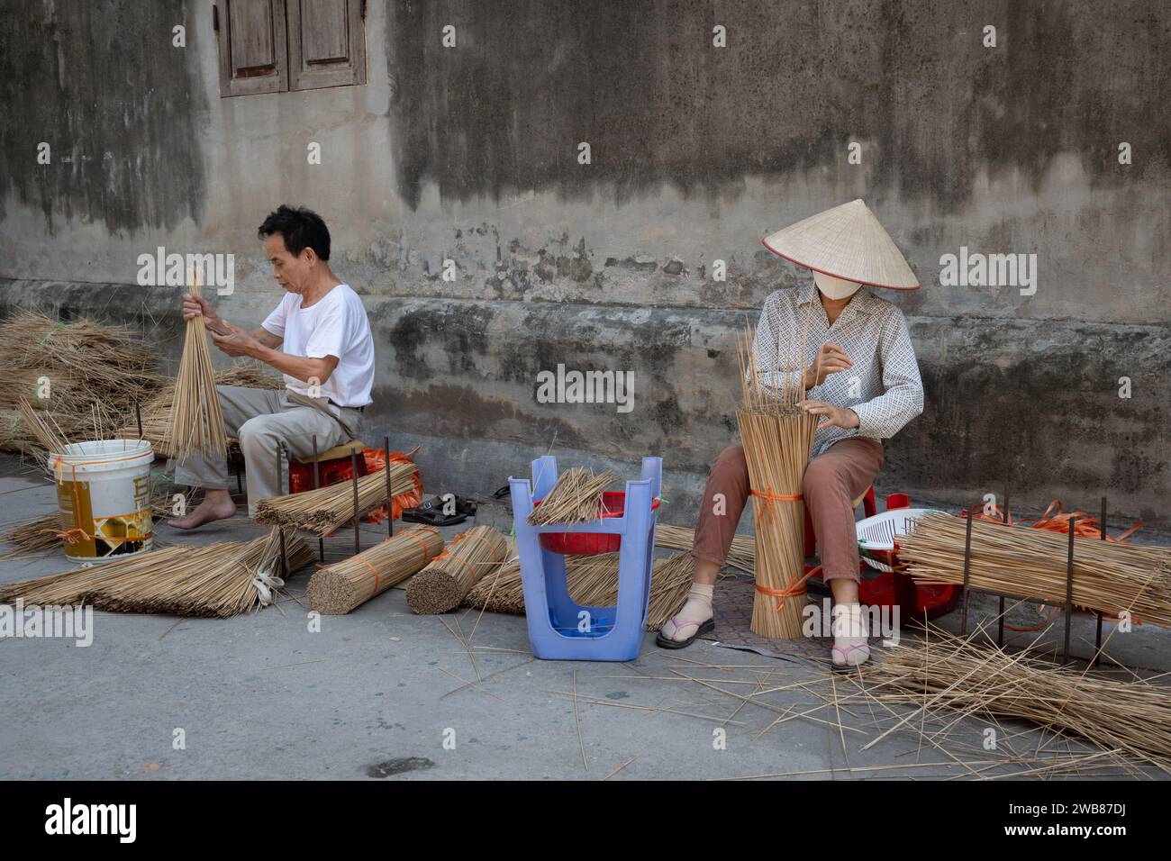 Man and woman making incense sticks at Quang Phu Cau Incense Village in ...