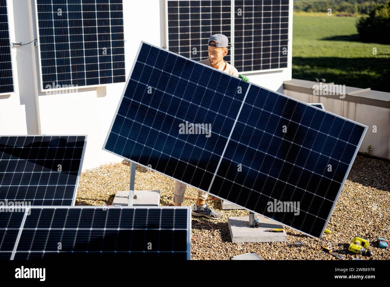 Man installing solar panels on a rooftop Stock Photo - Alamy