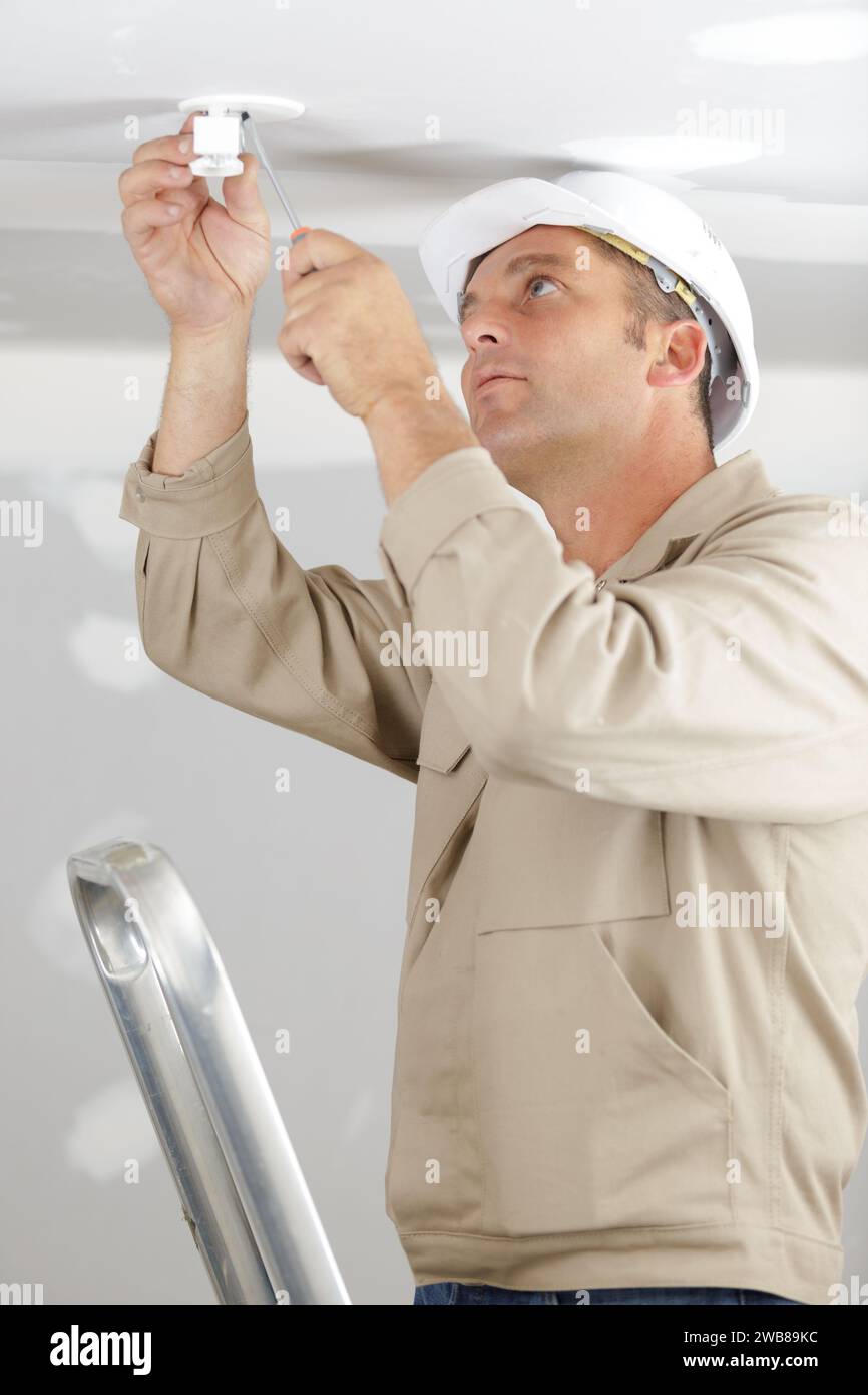electrician installing a light spot on the ceiling Stock Photo - Alamy